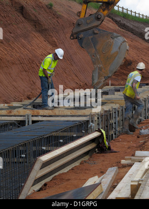 Pouring concrete into an excavator bucket for a placing concrete pour ...