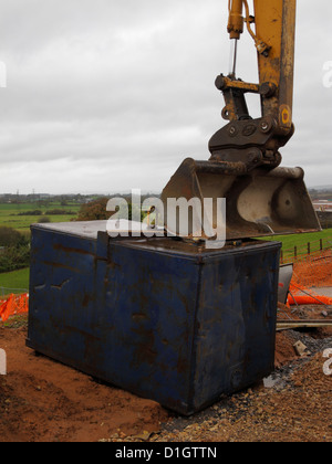 Digger bucket resting on a tank of diesel fuel to prevent theft on a UK ...