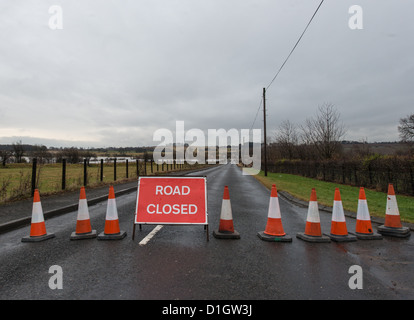 Road closed sign with traffic cones blocking a UK road, set in the ...