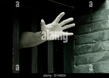 Prisoner hands stretch out from prison bars Stock Photo - Alamy