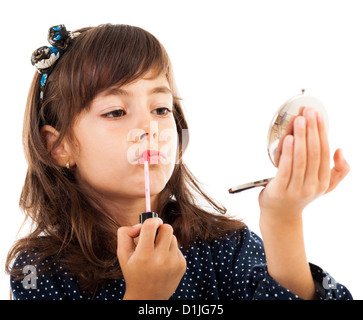 Lovely little girl looking at lipstick tube with astonished face ...