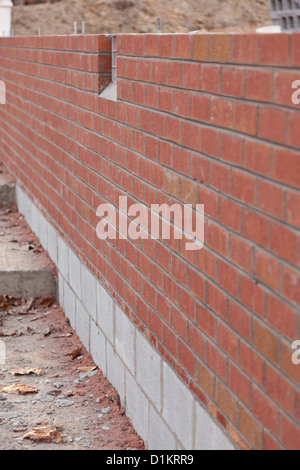 Brick wall under construction: building and home construction concept ...