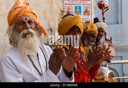 Four Indian men in turbans sitting on the ground having a conversation ...