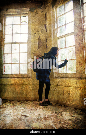 Scared woman looking out of a window Stock Photo - Alamy