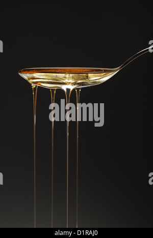 Dripping honey on black background Stock Photo - Alamy