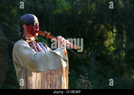 A Native American Indian man playing a flute outside in nature Stock ...
