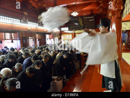 A Shinto priest performs a purification ritual by waiving a harai-gushi ...