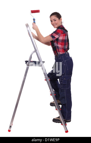 Woman using a roller to paint a ceiling in a residential house Cardiff ...