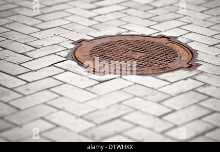 Rusty metal manhole cover in the pavement Stock Photo - Alamy