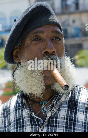 Mature man smoking a cigar and posing with folded arms isolated on ...