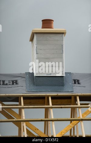 A fake artificial plastic chimney on the roof of a new house being ...