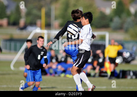 Soccer player plays the ball off his chest while shielding the effort ...