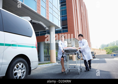 doctors moving a carrier ungently into the hospital Stock Photo - Alamy