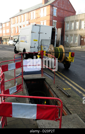 BT telephone engineers working in street and accessing underground ...