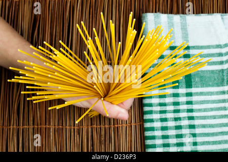 Female hand holding spaghetti. Green background Stock Photo - Alamy