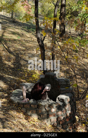 Horror woman crawling out of a brick well Stock Photo - Alamy