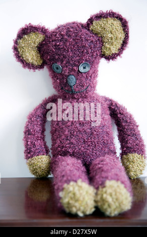 A vertical shot of a cute teddy bear on a black sofa Stock Photo - Alamy