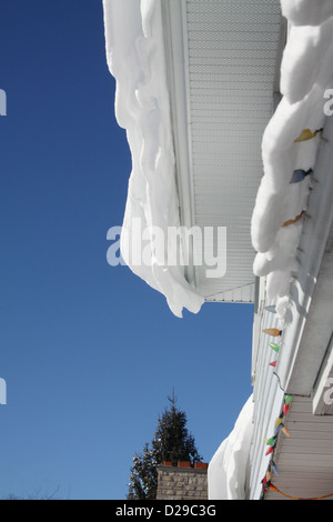 Snow hanging from and over the eaves of a house Stock Photo - Alamy