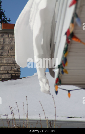 Snow hanging from and over the eaves of a house Stock Photo - Alamy