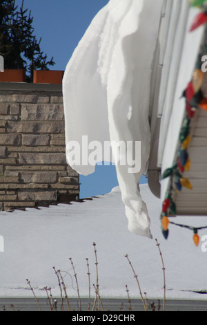 Snow hanging from and over the eaves of a house Stock Photo - Alamy
