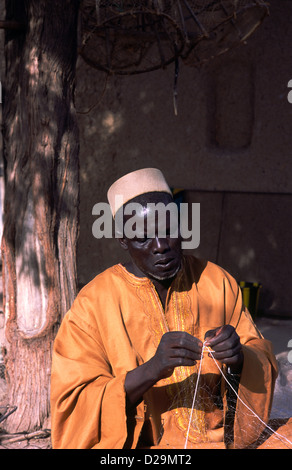 A Bozo fisherman preparing his nets in Mali, West Africa. Bozo are one ...