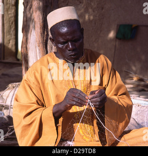 A Bozo fisherman preparing his nets in Mali, West Africa. Bozo are one ...