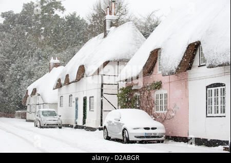 Snow falling on thatched cottages in the picturesque village of ...