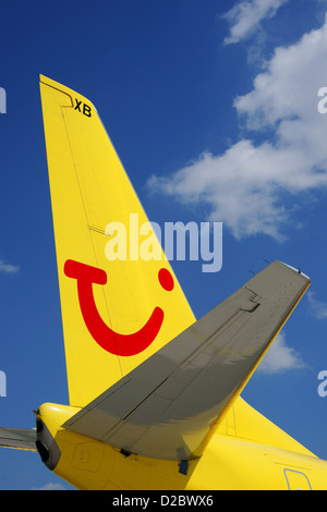 Boeing 737 aircraft of TUI airlines flying across a blue sky leaving a ...