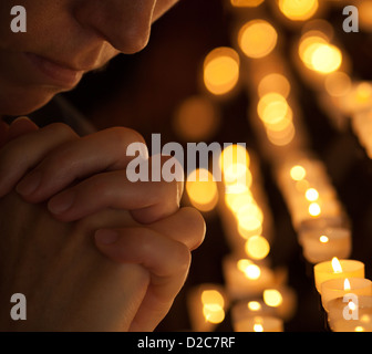 PRAYING HANDS WITH CANDLES Stock Photo - Alamy