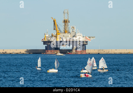Optimist dinghies sailing in front of Island Innovator semi submersible ...