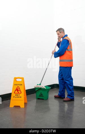 Cleaner mopping with wet floor sign with bright background Stock Photo ...