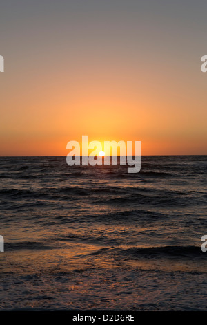 Sun setting at sea Stock Photo - Alamy