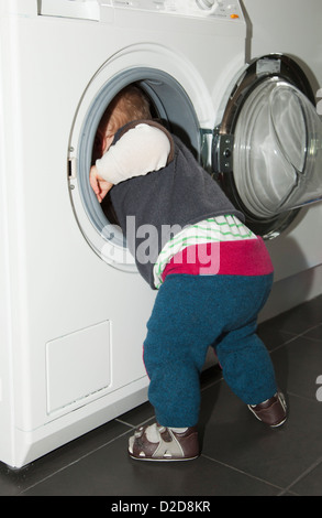 Baby reaching into a washing machine Stock Photo - Alamy