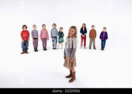 Cheerful girl standing in kids clothes boutique and choosing white ...