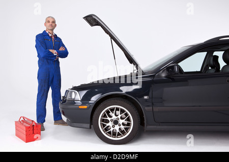 Auto mechanic standing with crossed arms Stock Photo - Alamy