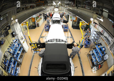 Employees work on cars of the model Porsche 911 at a manufacturing ...