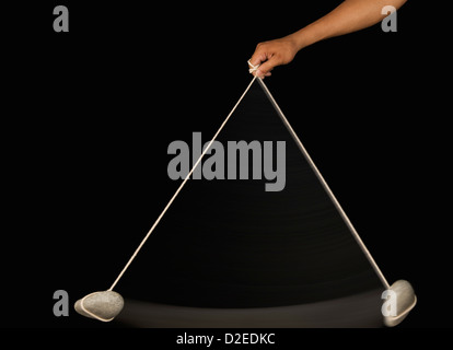 Hand holding a swinging pendulum Stock Photo - Alamy