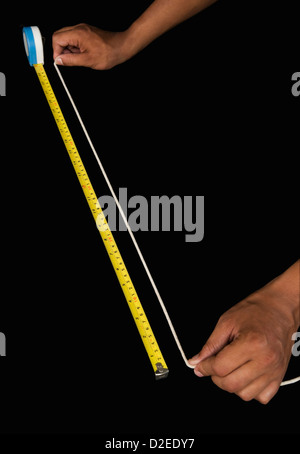Close-up of a man measuring string with a tape measure Stock Photo - Alamy