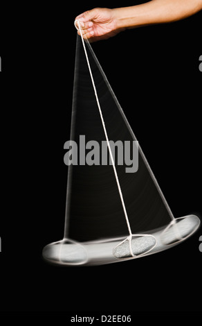 Hand holding a swinging pendulum Stock Photo - Alamy