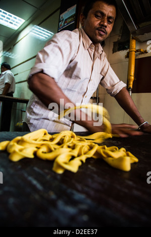 Indian man cooking deep fried Indian bread Wadai made from wheat flour ...