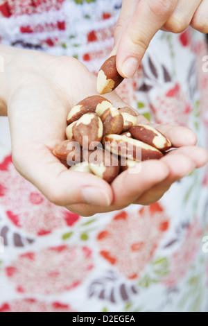 Healthy woman eating Brazil nuts in park on summer Stock Photo - Alamy