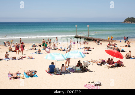 Crowded beach full of sunbathers and swimmers at one of Australia's ...