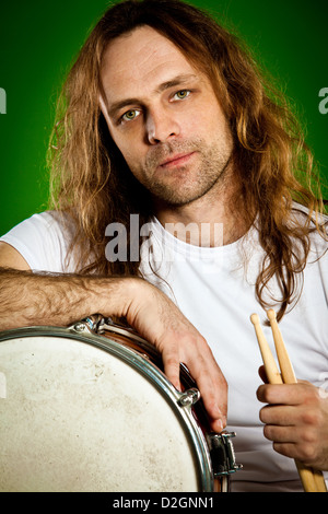 Portrait of the drummer man on a green background Stock Photo - Alamy