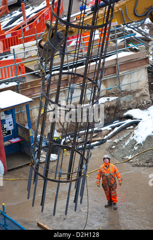 Plunge pile column steel directed into place by workers at the ...