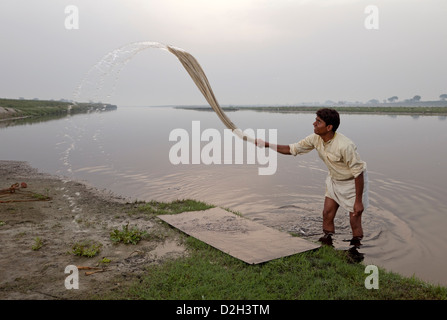 Dhobi wallah washing laundry in the river with neatly arranged washing ...