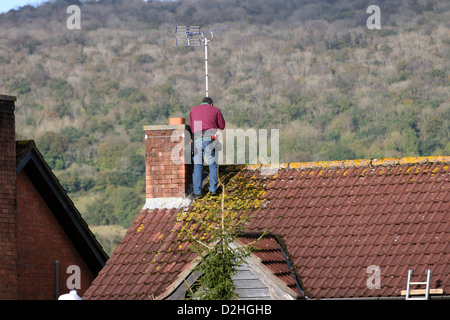 Television aerial installation men fixing a new aerial to a house roof ...