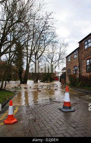 flood waters from Cod Beck, Thirsk, which has burst its banks, pouring ...