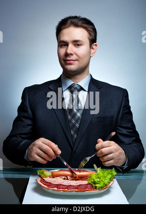 Young man eating tasty food on barbecue party Stock Photo - Alamy