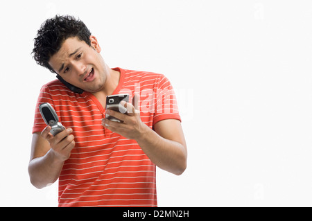Man looking at multiple cell phones Stock Photo: 14566630 - Alamy