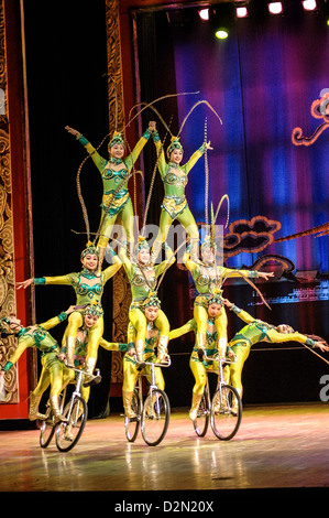 Chinese acrobats balance on a bicycle during performance in a theatre ...